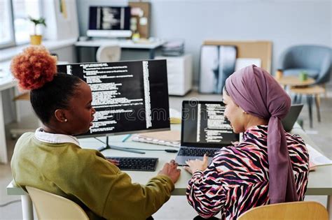 Back View At Two Female Programmers Writing Code Together Stock Photo