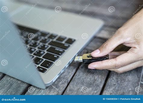 Hand Inserting USB Flash Drive Into Computer Laptop On The Desk Stock