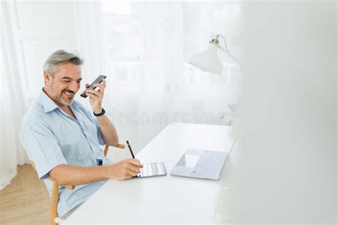 Mature Adult Man Using Voice Recognition On Mobile Phone Speaker Phone