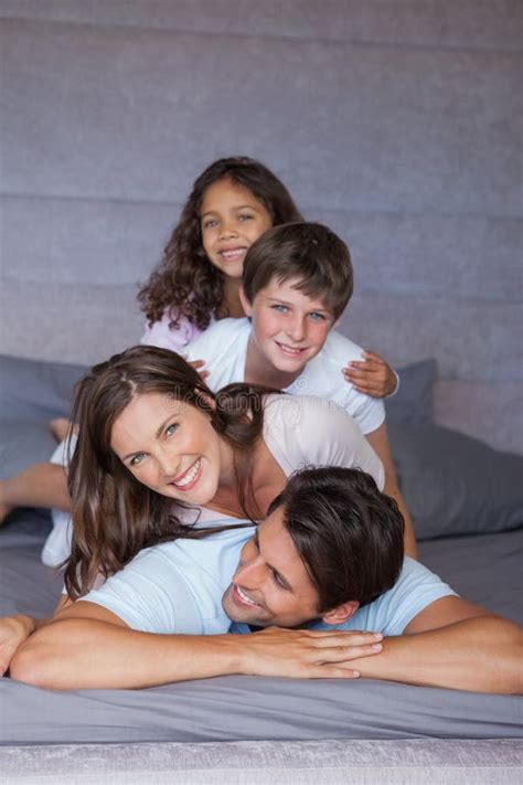 Familia Sonriente Que Juega Junto En La Cama Imagen De Archivo Imagen De Nightwear Feliz
