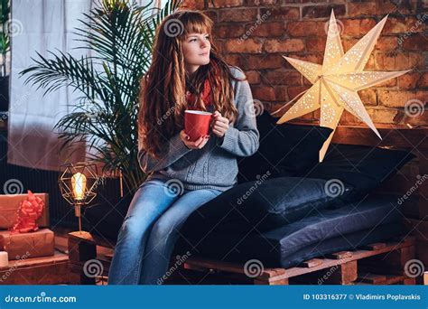 Redhead Female Drinks A Hot Coffee In A Living Room Stock Image