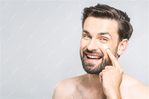 Premium Photo | Skin care. handsome young shirtless man applying cream ...