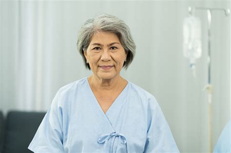 노인 아시아 여성은 병원 병동에서 가방에서 식염수를 받고 침대에 앉아 있습니다 의학 의료 노인 및 검역 개념 65 69세에 대한
