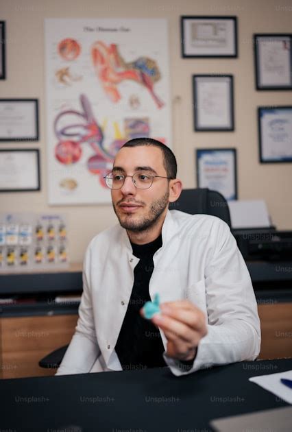 손에 펜을 들고 책상에 앉아 있는 남자 사진 Unsplash의 보청기 이미지