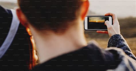 스마트폰을 사용하여 시골에서 놀라운 일몰 사진을 찍는 익명의 커플의 근접 촬영 일몰 사진을 찍는 자르기 커플 사진 Unsplash의 해질녘 이미지