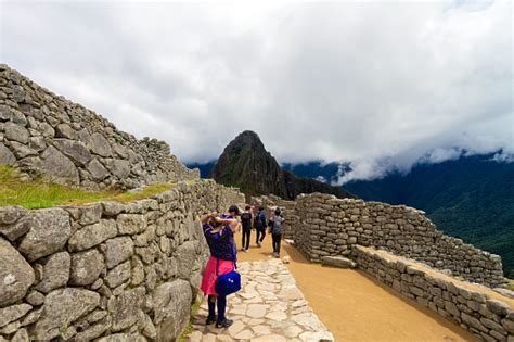 젊은 사람들의 그룹의 주택 백그라운드에서 산 Huayna Picchu 마 츄 피 츄의 복도 산책 고적에 대한 스톡 사진 및 기타