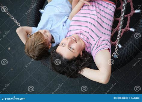 Happy Young Mother Playing With Her Son On The Playground Hugging