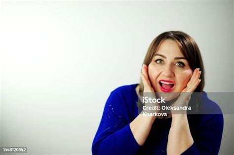 인간의 감정과 감정 성인 귀여운 여자는 프레임을 들여다보고 수줍게 웃으며 머리를 흔들고 눈을 감고 웃는다 농담은 조금 저속했고