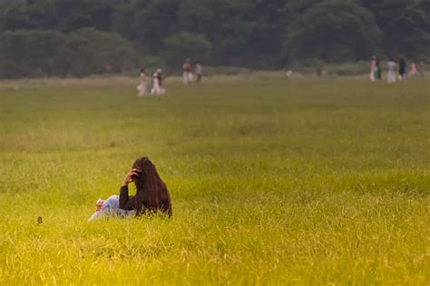 예쁜 녹색 잔디에 앉아 쾌활 한 여자와 달려있다 청 녀 또는 소녀 녹색 초원 보고 자연을 즐기는 여름 저녁 갈색 머리에 대한