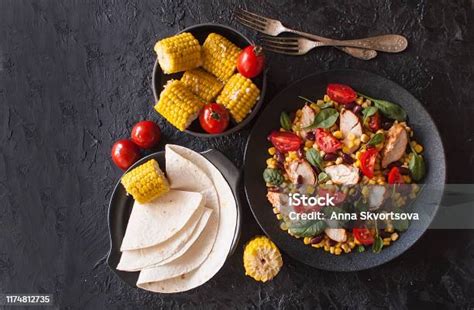 검은 어두운 배경에 스콘 야채와 닭고기의 멕시코 샐러드 옥수수 토마토 고추 콩 타코 믹스 상단에서 보기입니다 복사 공간 건강한