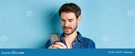 Close Up Portrait Of Happy Young Man Reading Mobile Sreen Networking In Smartphone Standing On