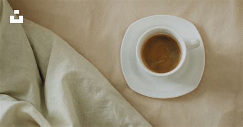 베개 옆 침대 위에 앉아 커피 한 잔 사진 Unsplash의 무료 웰빙 이미지