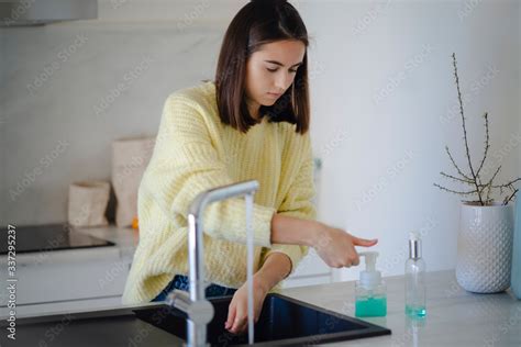 Young Pretty Girl Washing Hands With Soap On Her Kitchen During The