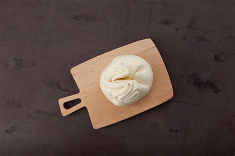 도마에 이탈리아 소프트 치즈 최고 전망 모짜렐라와 크림 필기로 만든 부라타 또는 부라티나 치즈의 흰 공 갈색 배경 복사 공간 0