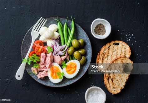 건강 한 아침 식사 또는 간식접시 참치 통조림된 녹색 콩 모 짜 렐 라 치즈 토마토 삶은 계란 올리브 구운 빵 어두운 배경
