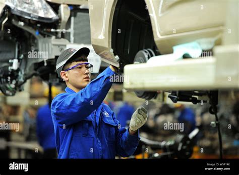 File A Chinese Worker Assembles Cars On The Assembly Line At The