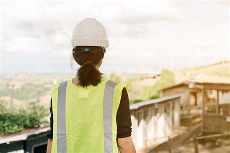 아시아 여성 엔지니어 흰색 안전 모자를 착용 녹색 안전 셔츠 건설 검사에 대 한 스탠드 건설 지역에서 건설 산업에 대한 스톡 사진 및 기타 이미지 Istock