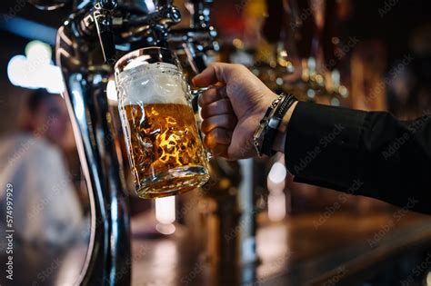 Man Bartender Hand At Beer Tap Pouring A Draught Beer In Glass Serving