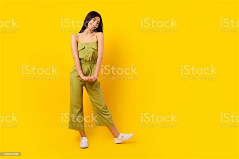 노란색 배경에 고립 된 빈 공간을 포즈를 취하는 멋진 쾌활한 소녀 이빨 미소의 전체 길이 초상화 갈색 머리에 대한 스톡 사진 및
