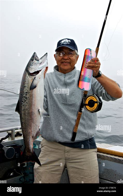 Asian Sport Fishing Angler Holding 20 Pound Chinook Salmon Rod Reel