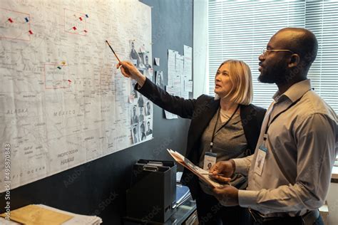 Foto De Two Fbi Agents Looking At Map On Board While Mature Female