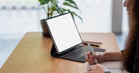 펜을 들고 있는 사업가가 사무실의 탁자 위에 메모와 태블릿의 빈 흰색 화면을 클로즈업합니다 모의 사진 Unsplash의 테이블 이미지