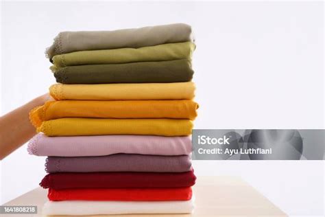 나무 탁자 위에 다양한 색깔의 천 더미가 쌓여 있고 하얀 배경에 분리된 화려한 면직물의 사진 더미가 있다 0명에 대한 스톡 사진 및 기타 이미지 Istock