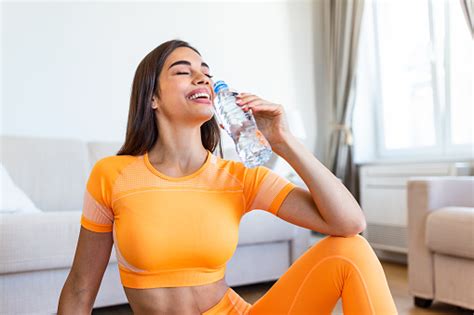 젊은 성인 여성 플라스틱 병에서 물을 마시는 피트 니스 매트에 앉아 집에서 훈련 후 휴식 20 24세에 대한 스톡 사진 및 기타 이미지 20 24세 건강한 생활방식