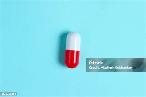 파란 배경에 백색 빨간 알 약 캡슐입니다 Minimalism 의료 개념 평면도 0명에 대한 스톡 사진 및 기타 이미지 0명
