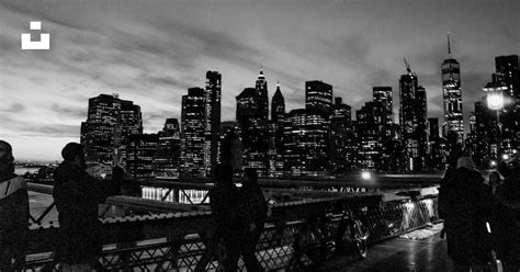 Foto Foto En Escala De Grises De Un Hombre Parado En Un Puente Cerca De