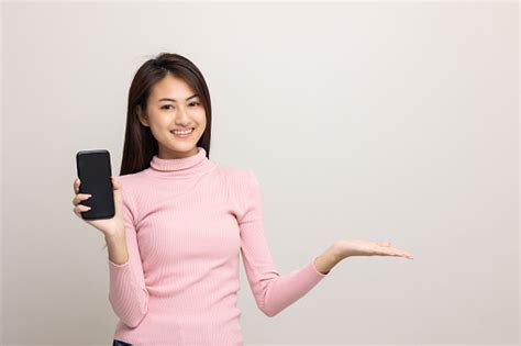 스마트 폰의 화면을 보여주는 예쁜 젊은 아시아 여성과 고립 된 흰색 배경에 서 뭔가를 들고 손을 손바닥 그녀는 매우 행복합니다 18 19세에 대한 스톡 사진 및 기타 이미지