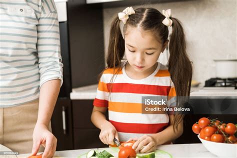 여자와 소녀는 샐러드를 위해 생야채를 자르고 가족 저녁 식사를 위한 음식을 준비하고 있습니다 2명에 대한 스톡 사진 및 기타 이미지 Istock