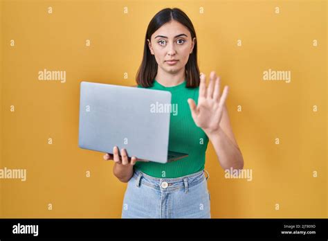 Hispanic Girl Working Using Computer Laptop With Open Hand Doing Stop