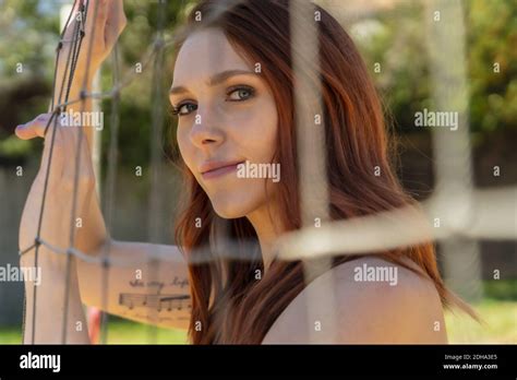 A Gorgeous Redhead Fitness Model Preparing To Play Volleyball Stock
