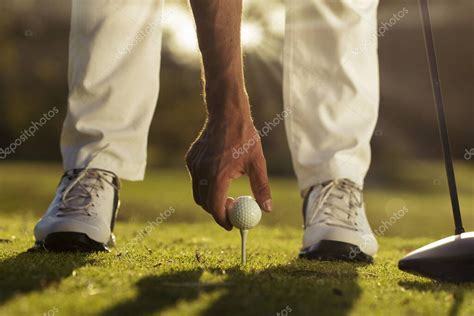 Golfistas Mano Colocando Pelota De Golf En La Camiseta De Cerca Con Los Pies Borrosos Y El Fondo