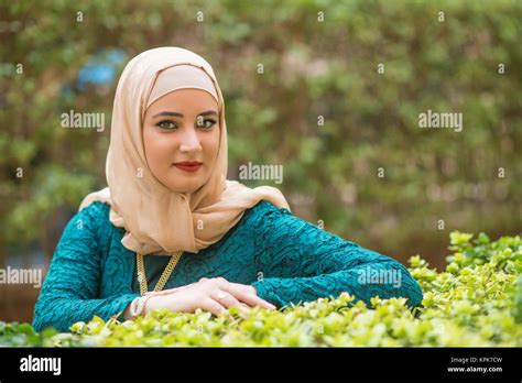 Belle Jeune Femme Musulmane Portant Le Hijab Se Penchant Sur Les Plantes En Plein Air Photo