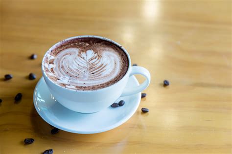 커피 라떼 아트 커피 예술 나무 테이블에 흰색 컵에 뜨거운 커피 핫 초콜릿 누텔라 라떼 아트 온 우드 테이블 갈색에 대한 스톡