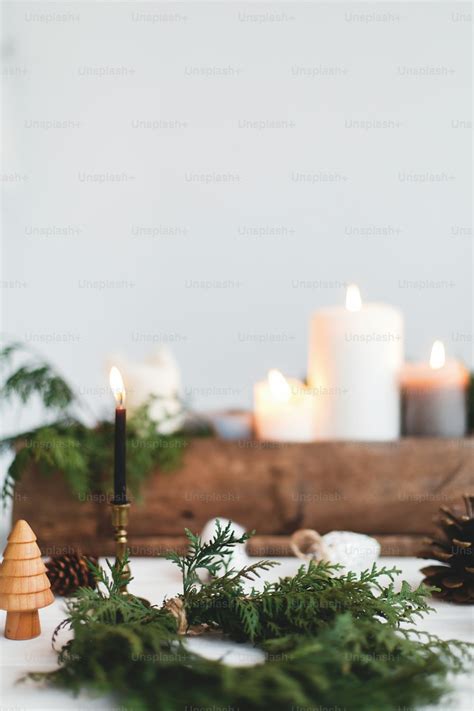 삼나무 가지로 간단한 세련된 크리스마스 화환 만들기 휴일 워크샵 강림 흰색 나무 테이블에 양초 솔방울 실 및 장식품이 있는 소박한 크리스마스 화환 사진