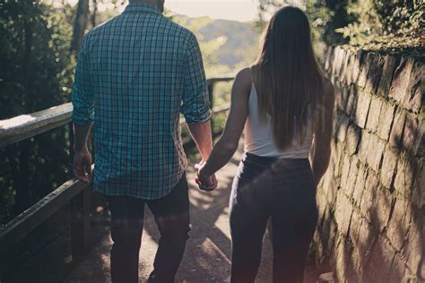 Foto De Vista Posterior De La Pareja Cogidos De La Mano Mientras Camina