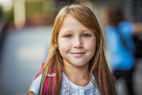 빨간 머리를 가진 쾌활한 소녀의 초상화는 카메라를 향해 웃고 있다 초점은 전경에 있습니다 사진 Unsplash의 공생 이미지