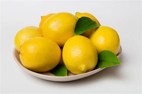 Lemon Segar Yang Dipotong Dan Lemon Utuh Di Atas Piring Bundar Dengan
