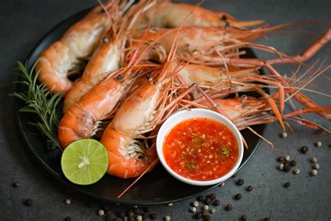 새우 구운 검은 배경에 맛있는 조미료 향신료 식욕을 돋우는 요리 새우 구운 새우 로즈마리 레몬 라임 고추 해산물 소스를 곁들인 해산물 선반 갑각류에 대한 스톡 사진 및 기타