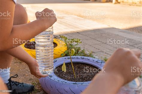 식물에 물을주기 위해 물 한 병과 함께 인식 할 수없는 아이들의 팔의 세부 사항 텍스트를위한 공간이있는 수평 사진 수자원 보호에