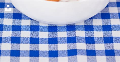 파란색과 흰색의 체크무늬 테이블 위에 계란이 가득 담긴 하얀 그릇 사진 Unsplash의 무료 음식 이미지