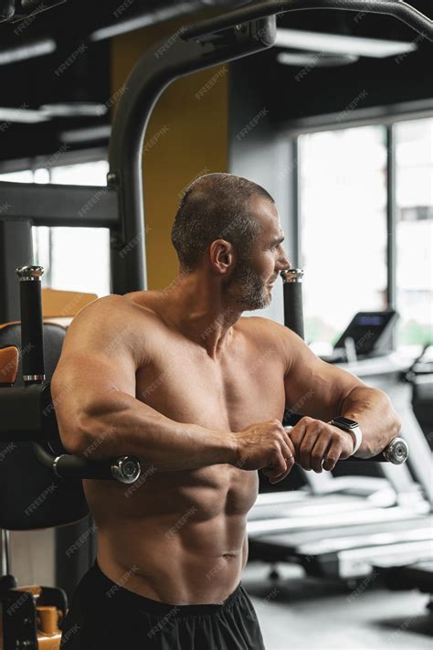 Premium Photo Muscular Bodybuilder Doing Dips For Triceps And Chest