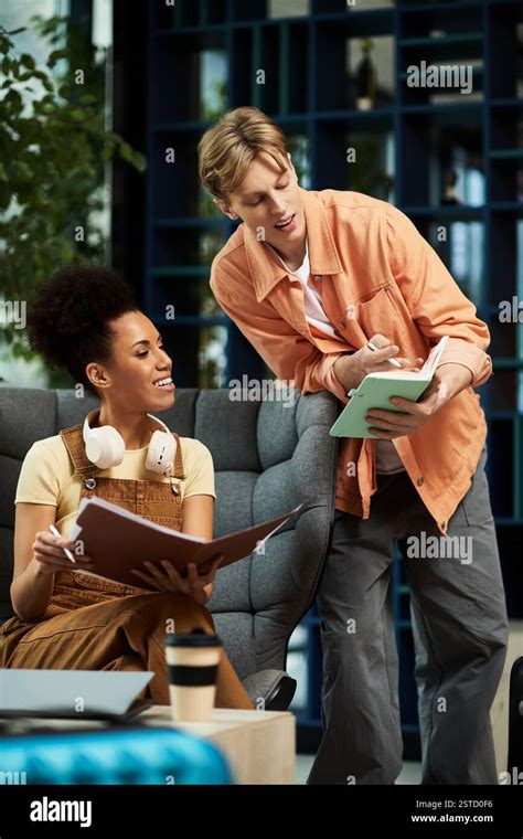 Two Colleagues Engage In A Lively Discussion While Reviewing Notes In A