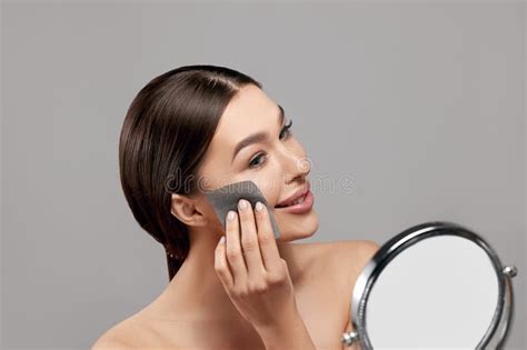 Skin Care Young Woman Removing Oil From Face Using Blotting Papers Looking In Mirror Stock