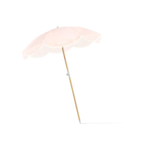 The Blush Beach Umbrella Features Pom Pom Fringe Details And A