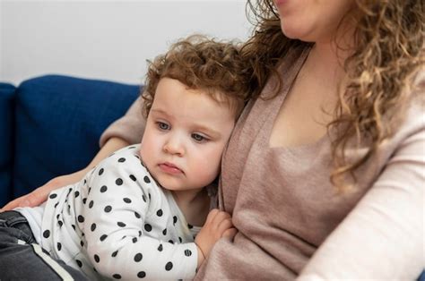 Mãe Segurando Seu Filho Pequeno No Sofá Foto Grátis