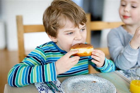 사랑 스러운 작은 유치원 남자와 달콤한 도넛을 먹는 여자 도넛에 대한 스톡 사진 및 기타 이미지 도넛 먹기 아이 Istock